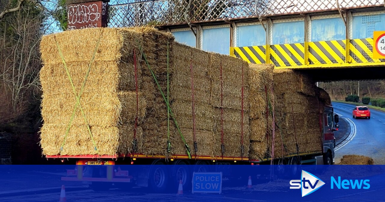 Lorry carrying bales of hay becomes stuck under railway bridge in ...
