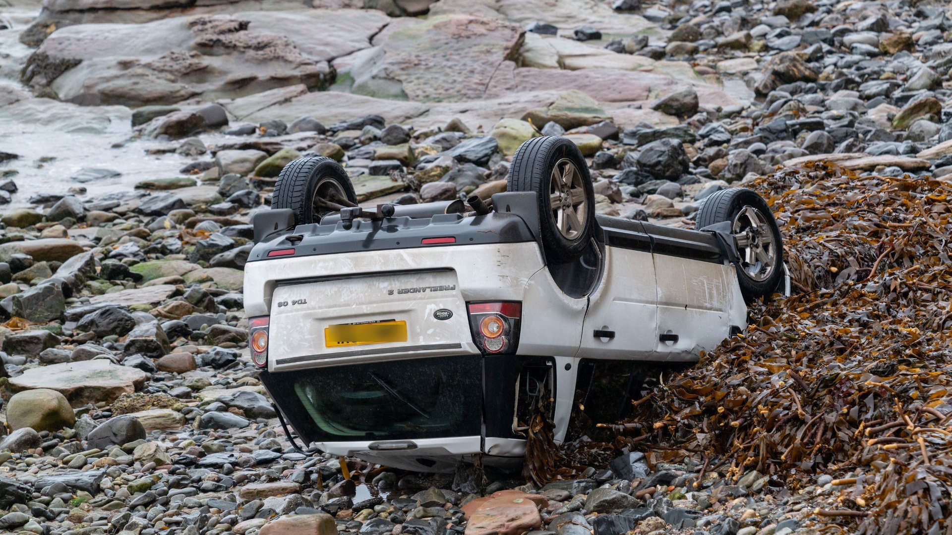 Woman charged after car lands on roof on shore at Gardenstown in ...