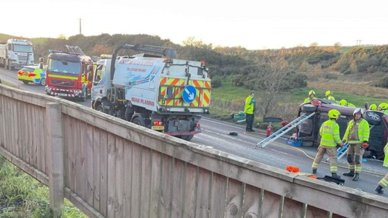Two in hospital as car crashes into 'sweeper lorry' and lands on side ...