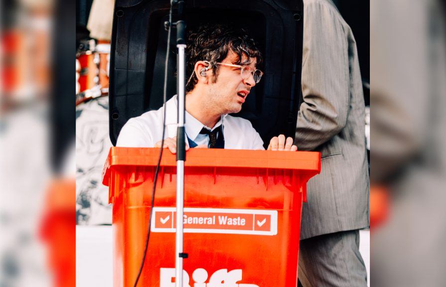 The 1975 frontman Matty Healy arrives in red wheelie bin to perform ...