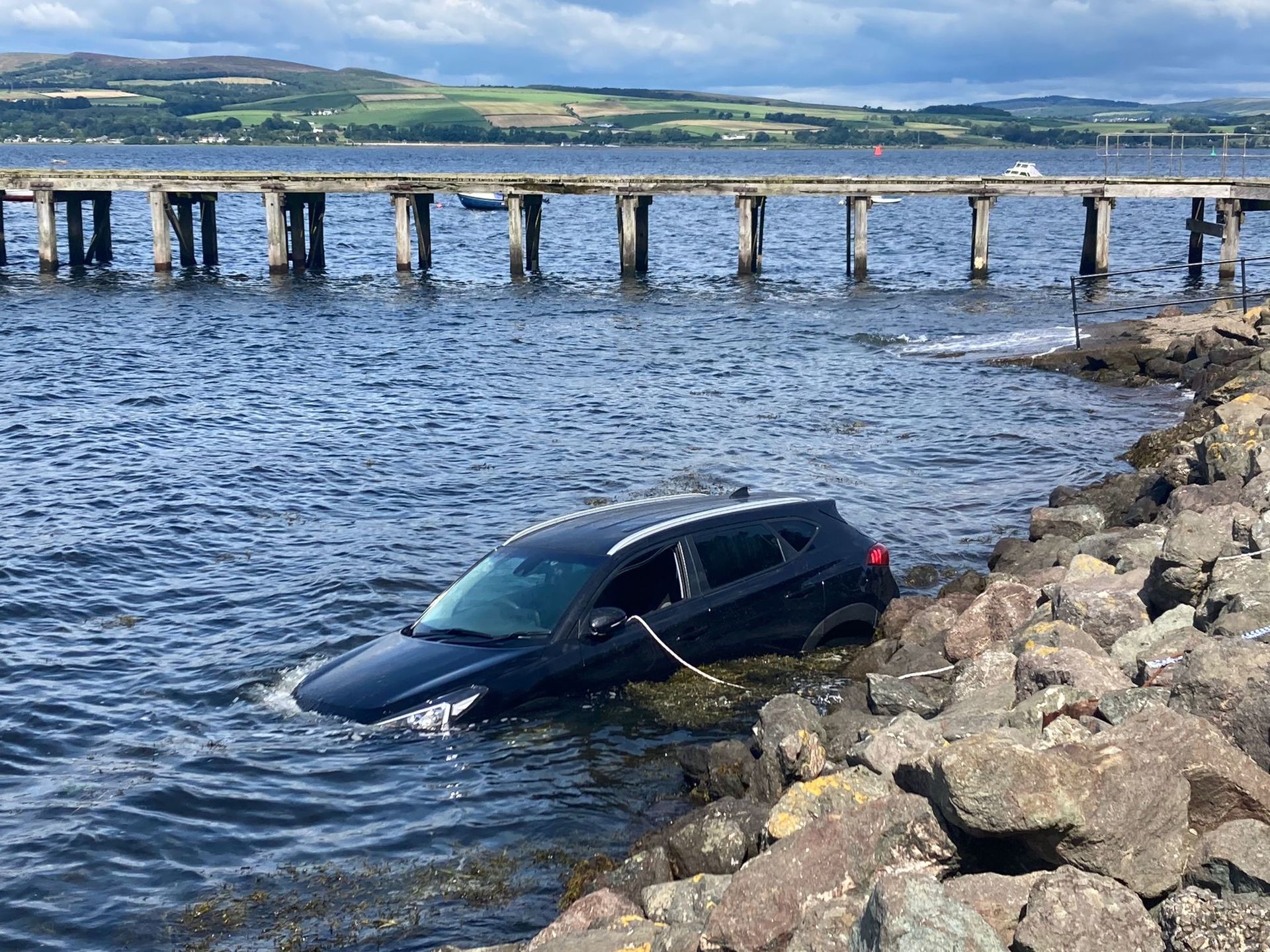 One person in hospital after three rescued from car which plunged into ...